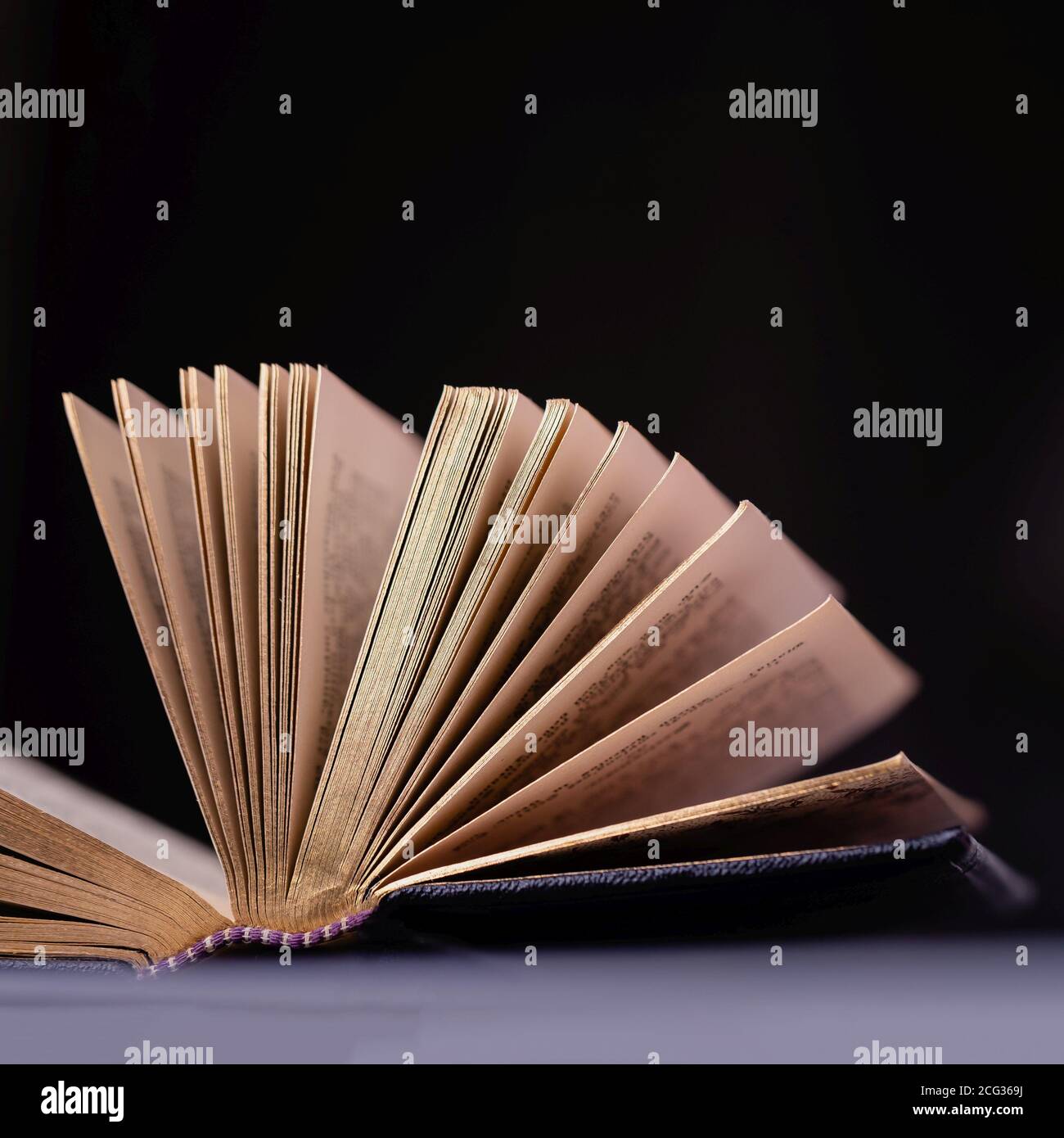 Opened old vintage book with gold pages on a black background Stock ...