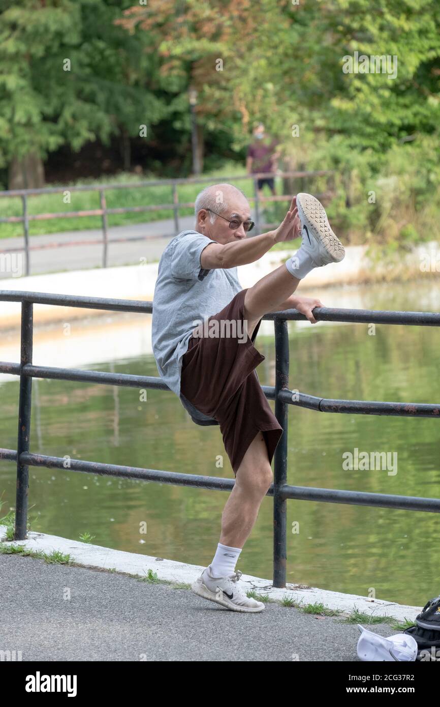 A nimble flexible senior citizen touches his toes in an unconventional ...