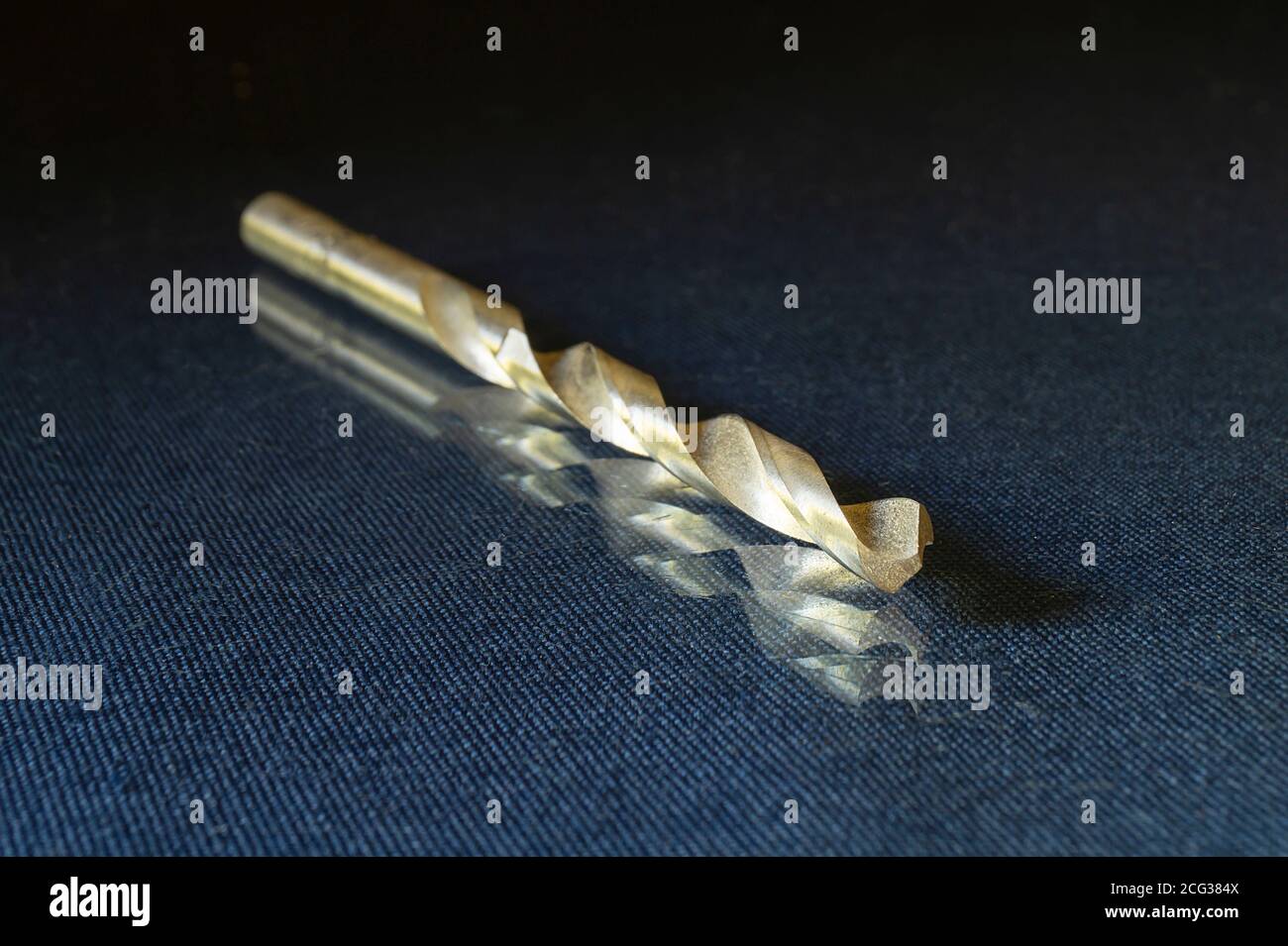 The Drill on metal on glass table on black background. The Instrument ...