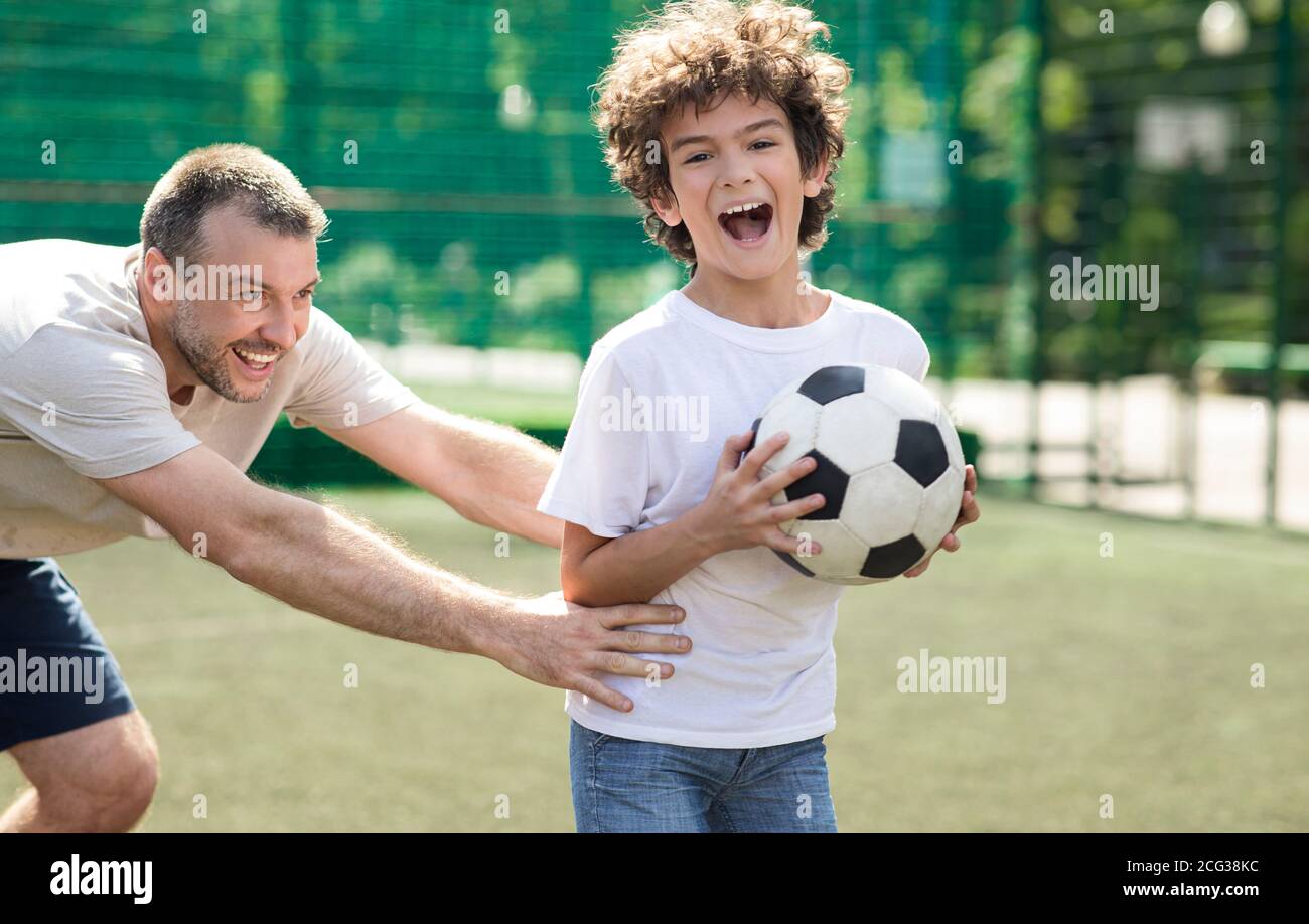 Sportive dad teaching his son how to play soccer Stock Photo - Alamy