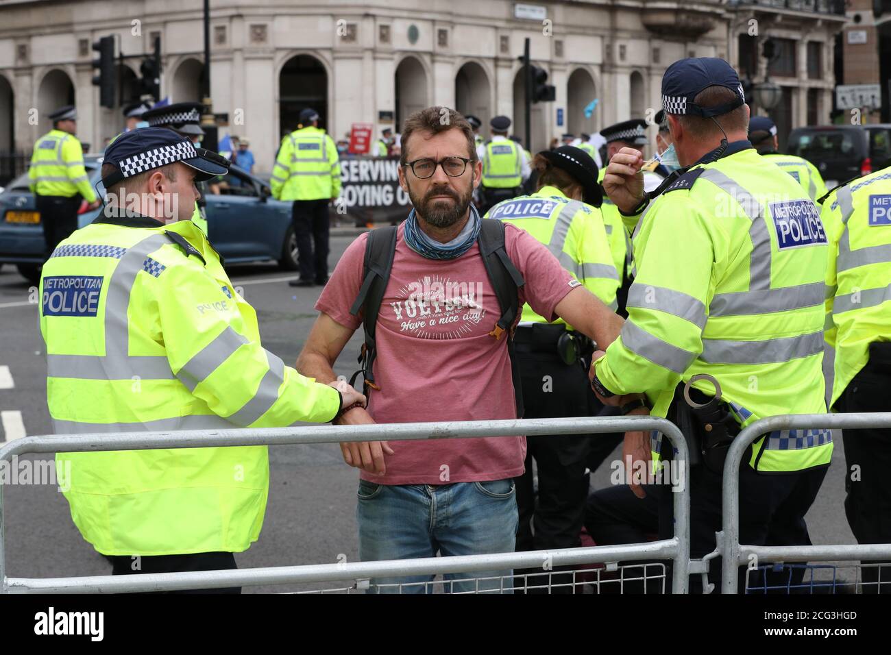 Police officers remove a protester who has sat down in the road from ...