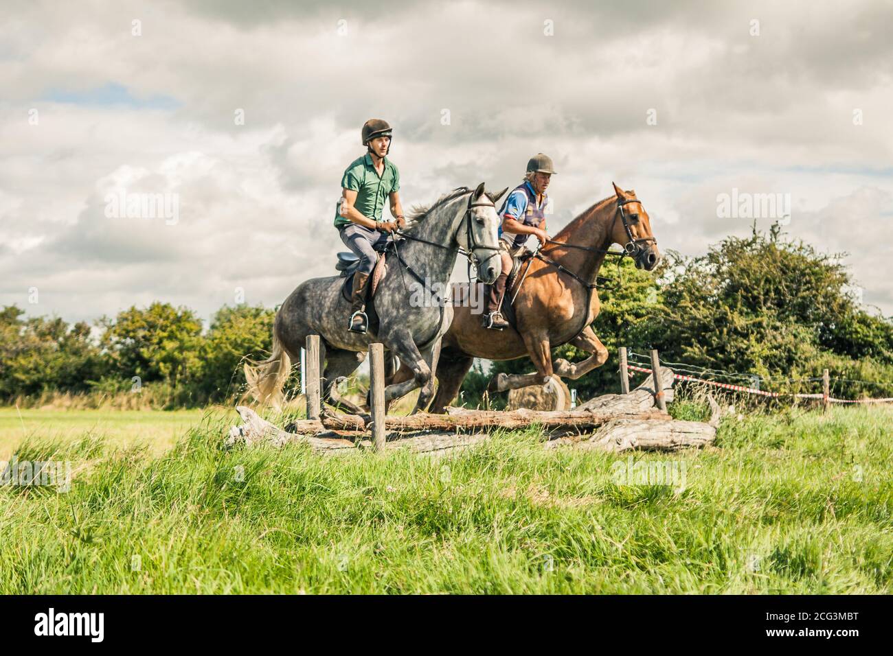 HORSE RIDING THROUGH FIELDS AND OVER JUMPS Stock Photo - Alamy