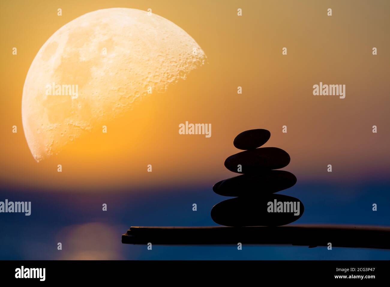 Zen stones pyramid on the background of the big moon and the sea Stock ...