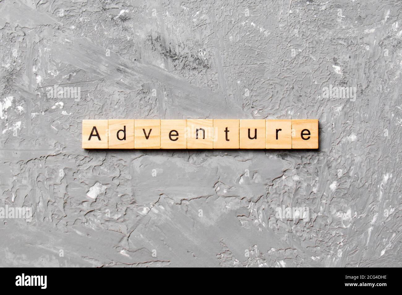 adventure word written on wood block. adventure text on cement table ...