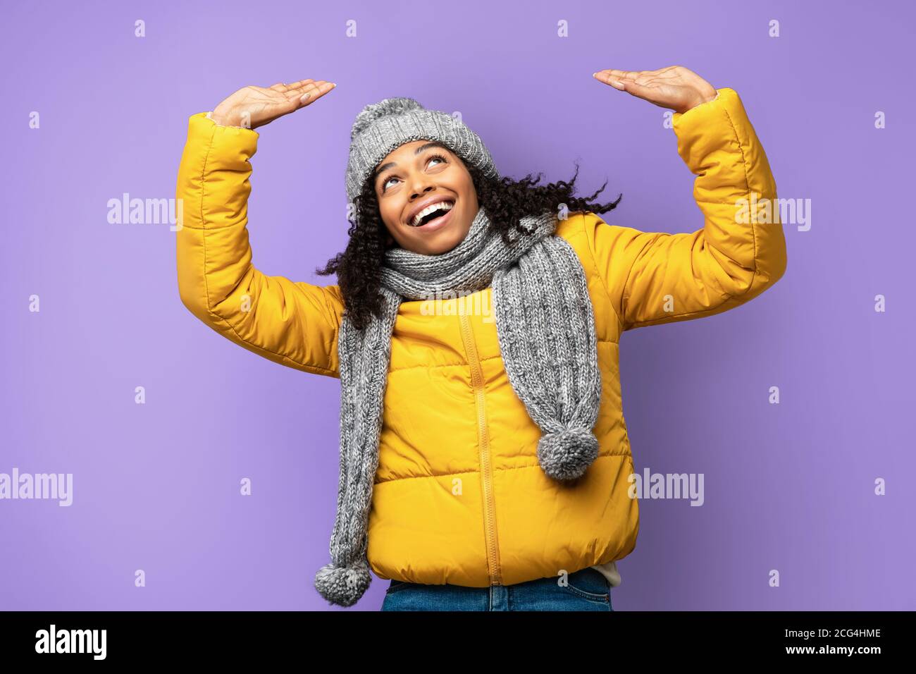 Cheerful Black Girl Holding Invisible Object Above Head, Purple ...