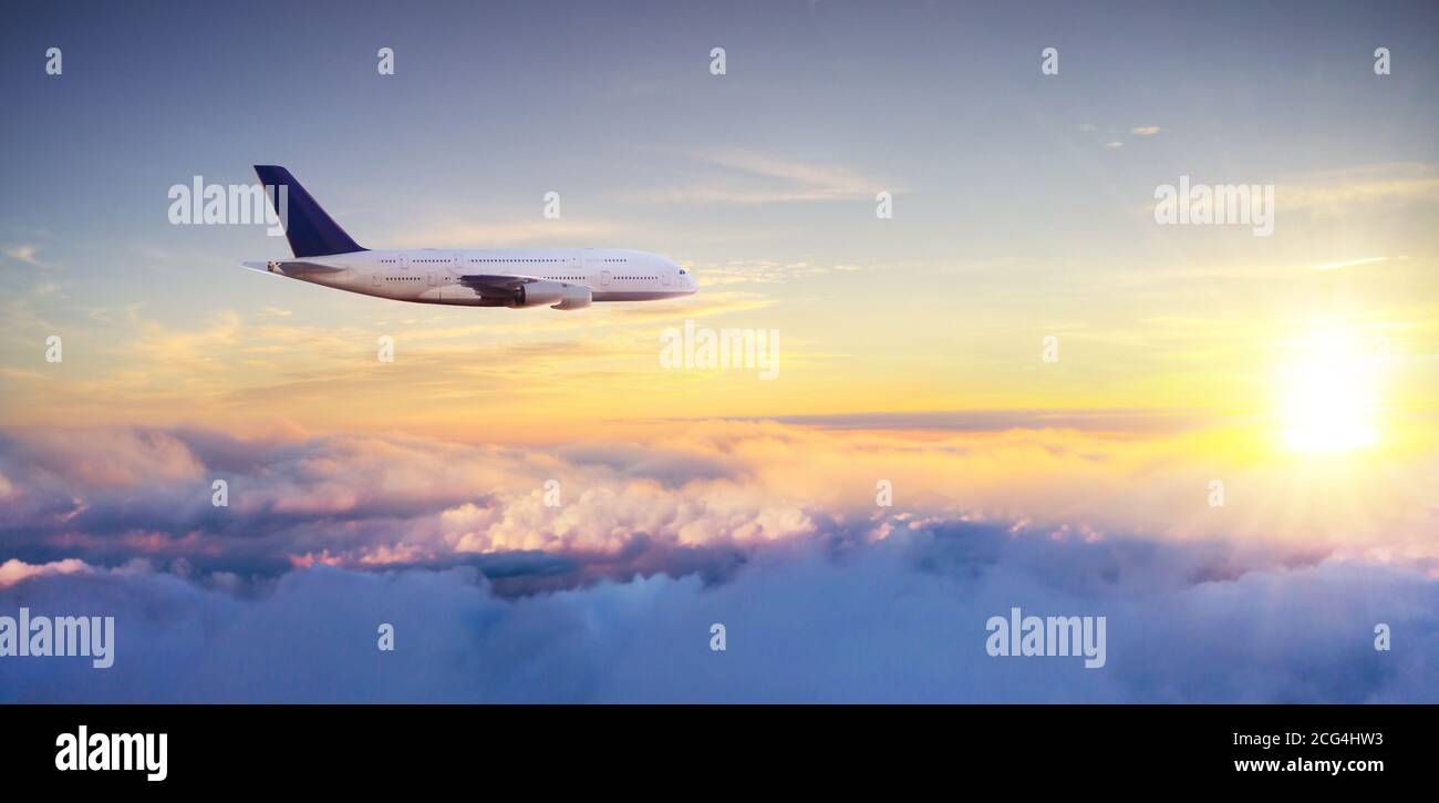 Commercial airplane flying above clouds, side view. Sunset light Stock ...