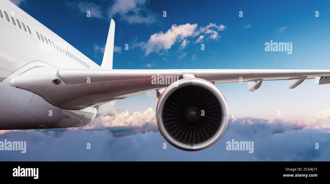 Detail of wing of commercial airplane jetliner flying above clouds in ...