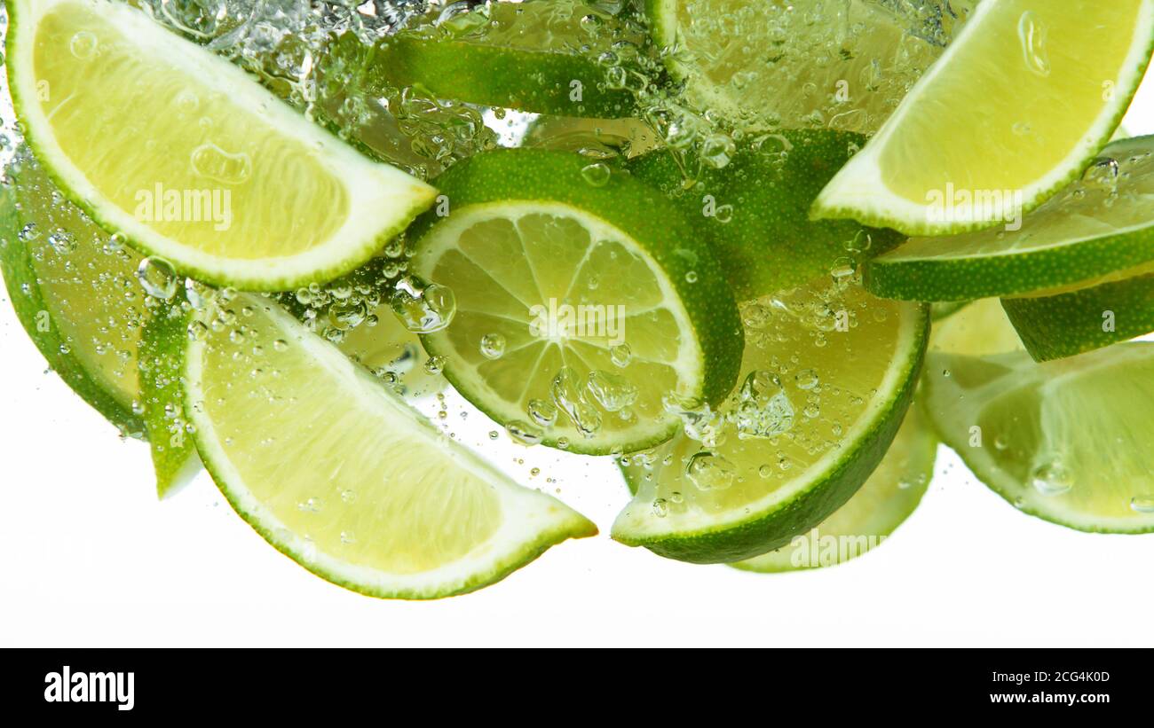 Lime Slices falling deeply under water isolated on white background Stock Photo - Alamy