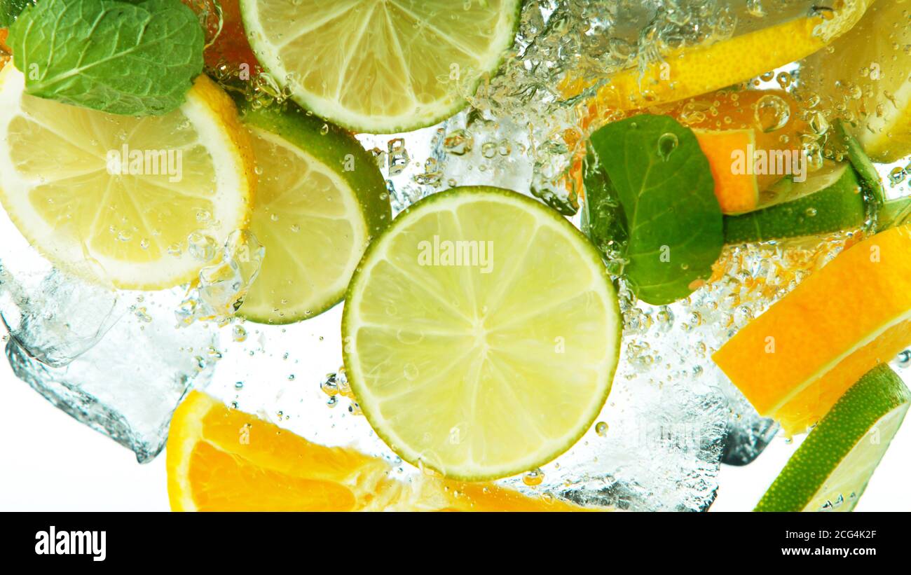 Lemon, orange and lime slices falling under water isolated on white ...