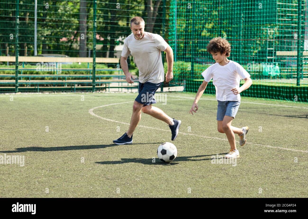 Sportive dad playing soccer with his son Stock Photo - Alamy
