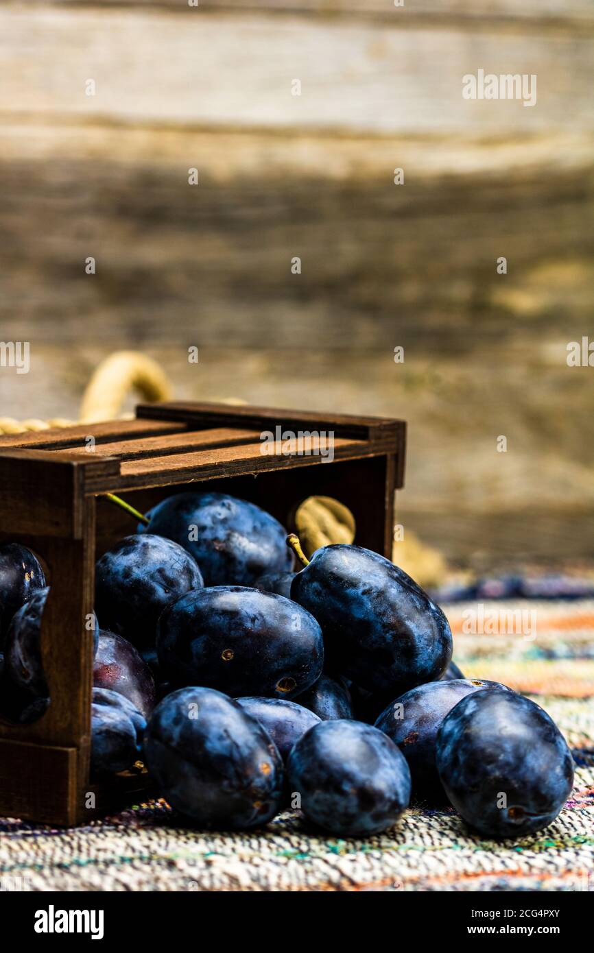 Ripe blue plums in a wooden crate in a rustic composition Stock Photo ...