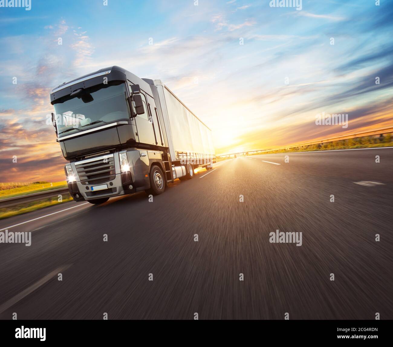 European truck vehicle on motorway with dramatic sunset light. Cargo ...