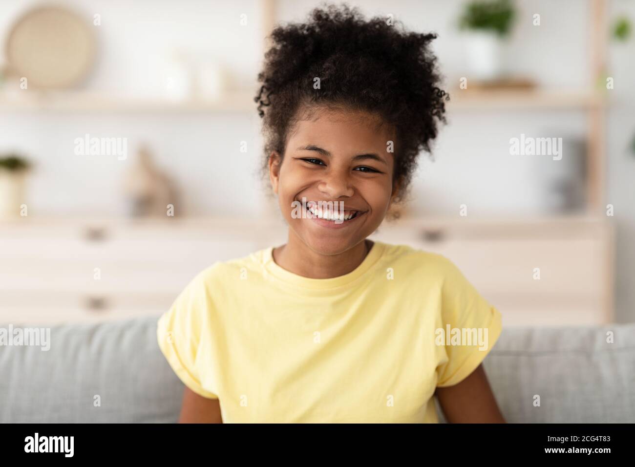 Positive Black Girl Laughing Sitting On Couch At Home Stock Photo - Alamy