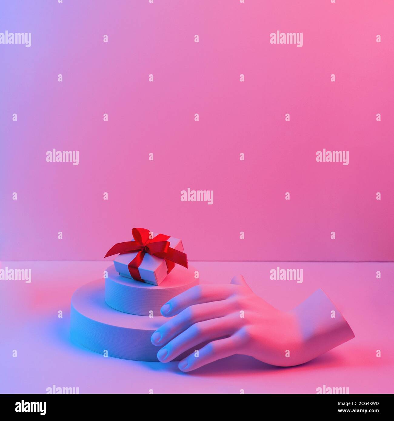 Composition with gypsum hand. A box with a red ribbon on the podium ...