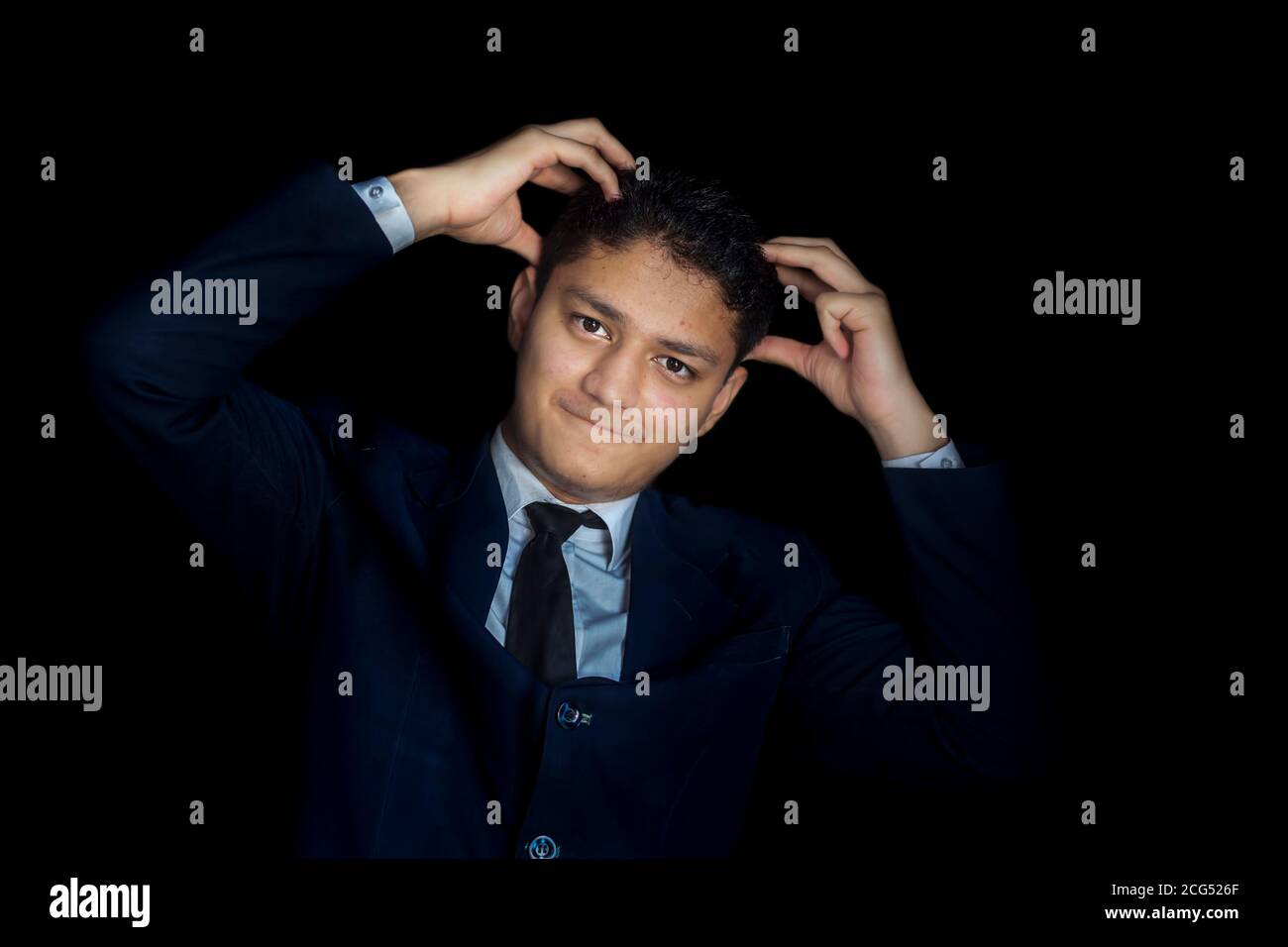 Frustrated man holding his head with tension and posing on a black ...