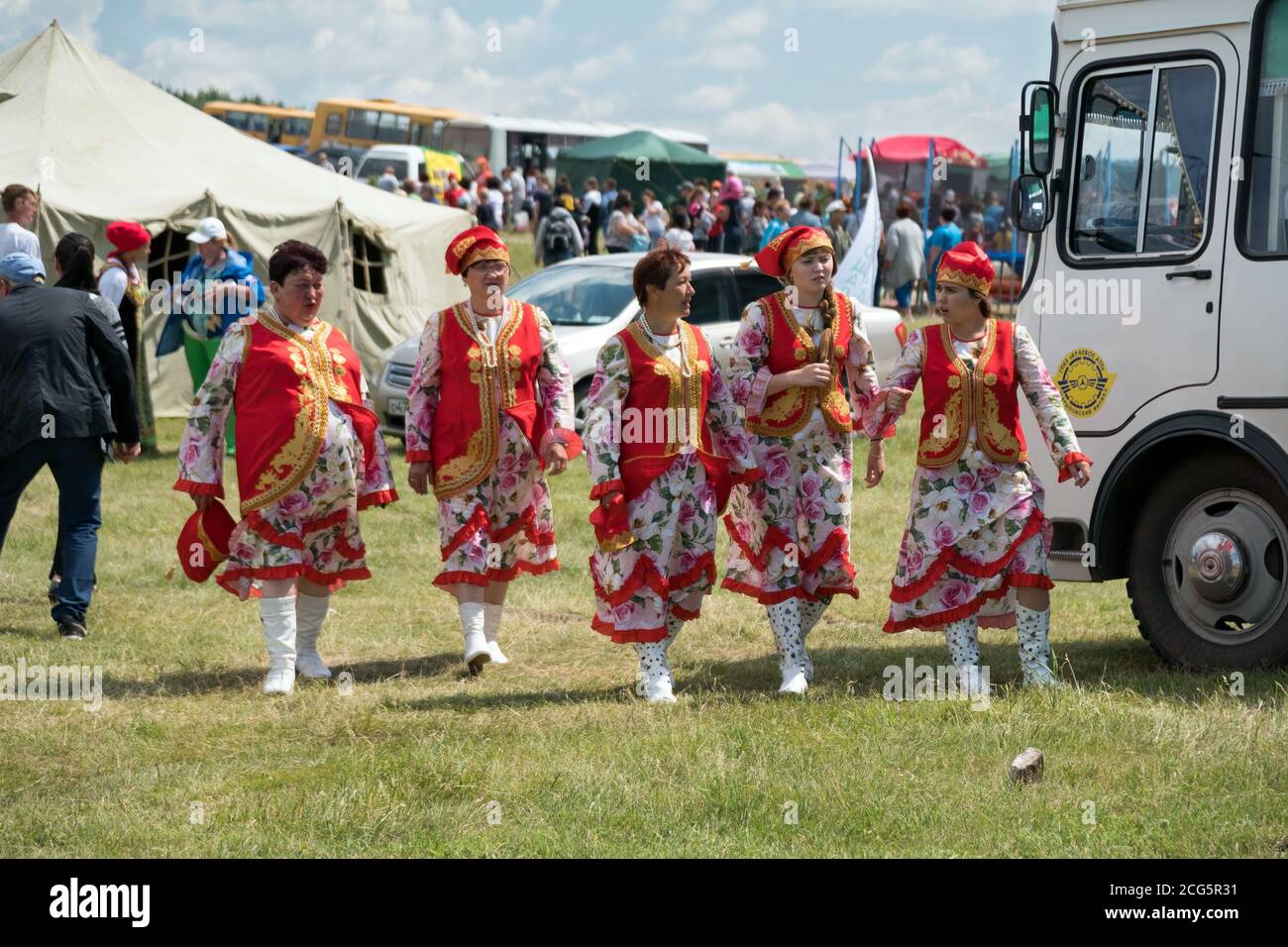 Women in Tatar folk costumes walk in the clearing at the Karatag music ...