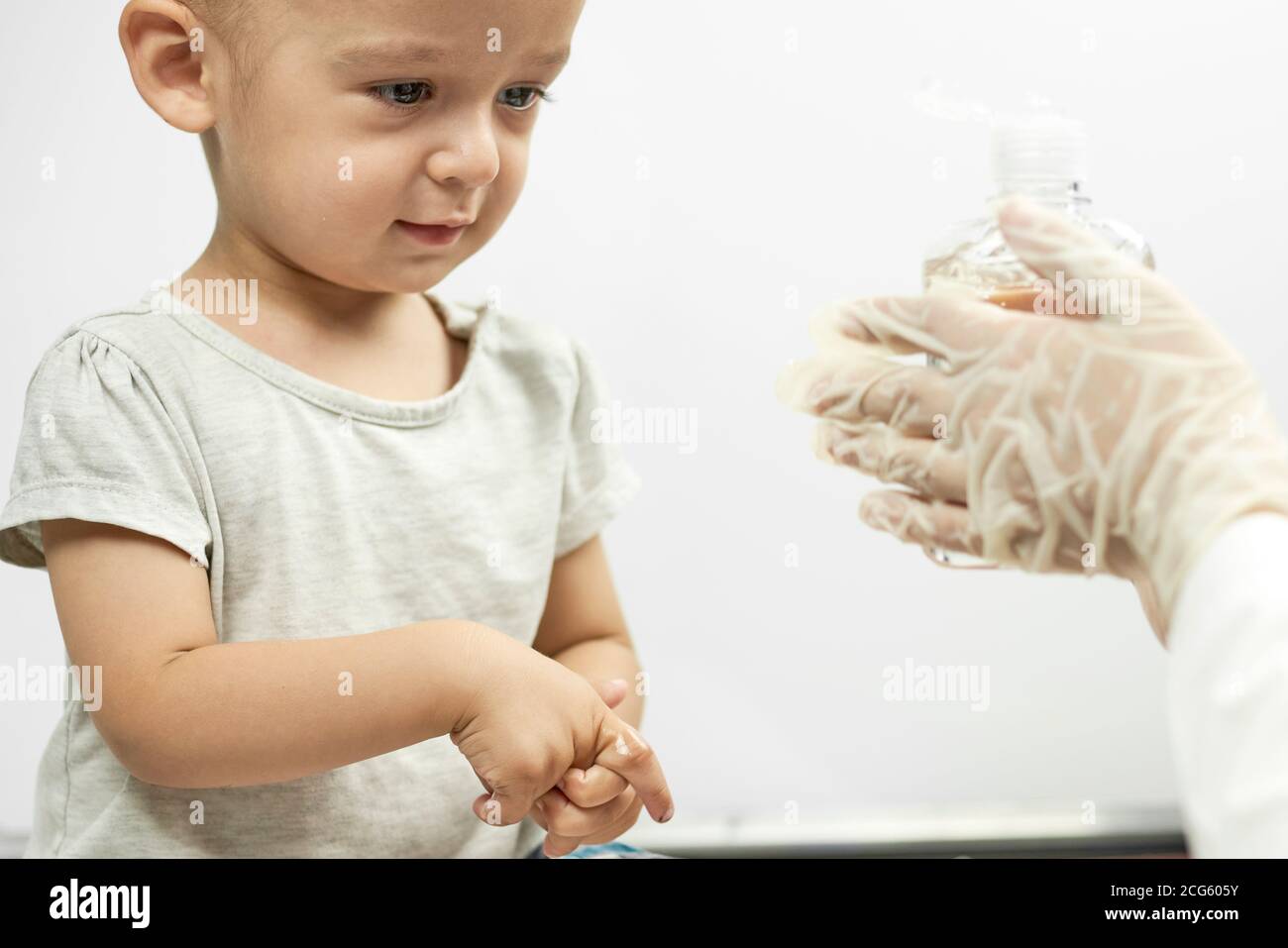 Doctor putting hand sanitizer to baby hands. Teaching a baby boy hand ...