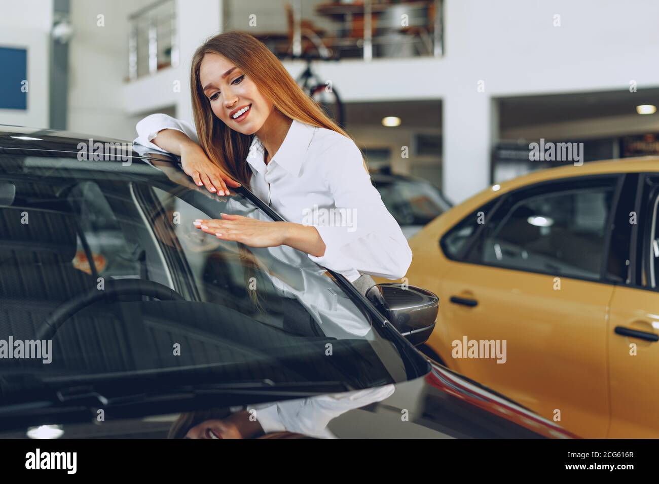 Beautiful young woman touching her new car with pleasure Stock Photo ...