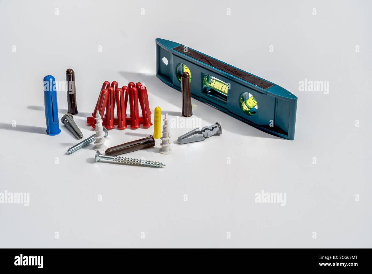 Small spirit level, wall anchors plugs and screws for a DIY project in ...
