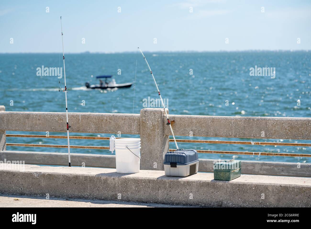 Photo of fishing poles and tackle boxes on a pier Stock Photo - Alamy
