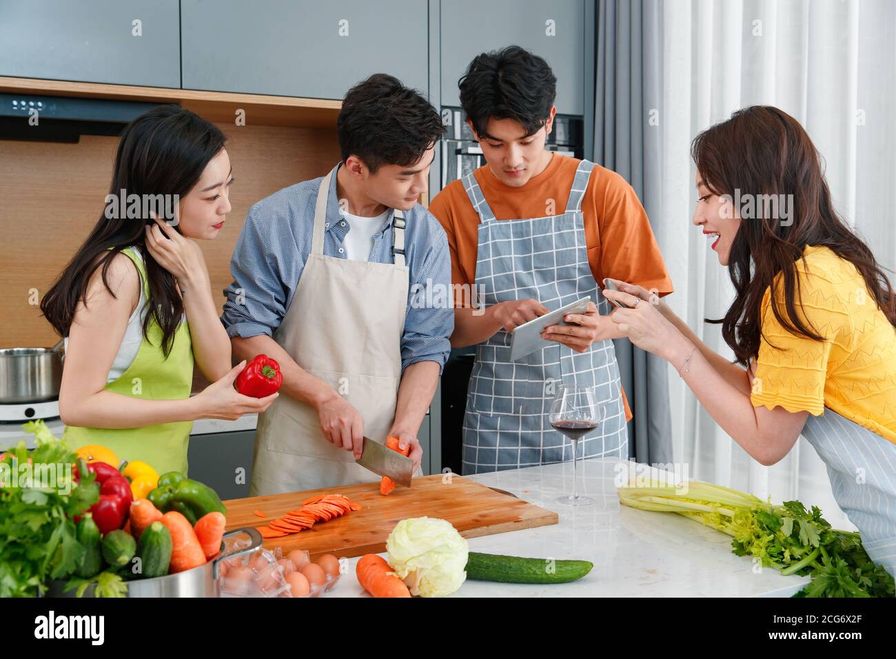 Happy young people cook in the kitchen Stock Photo - Alamy