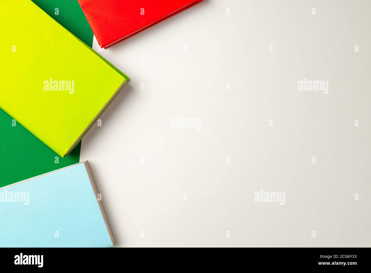 Three colorful notepads on desk top view Stock Photo - Alamy