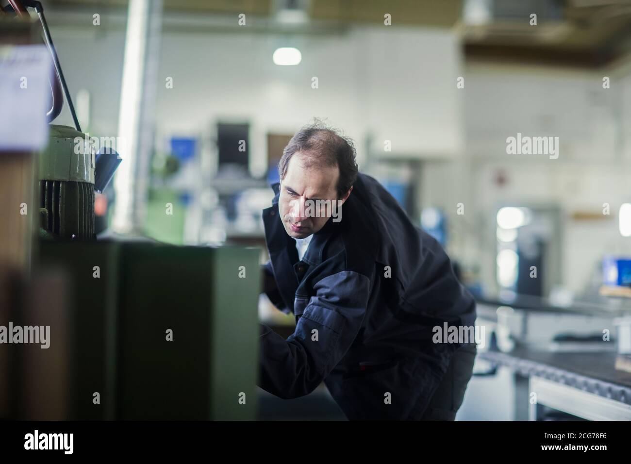 Engineer inspecting a machine part in an industrial plant, Germany ...