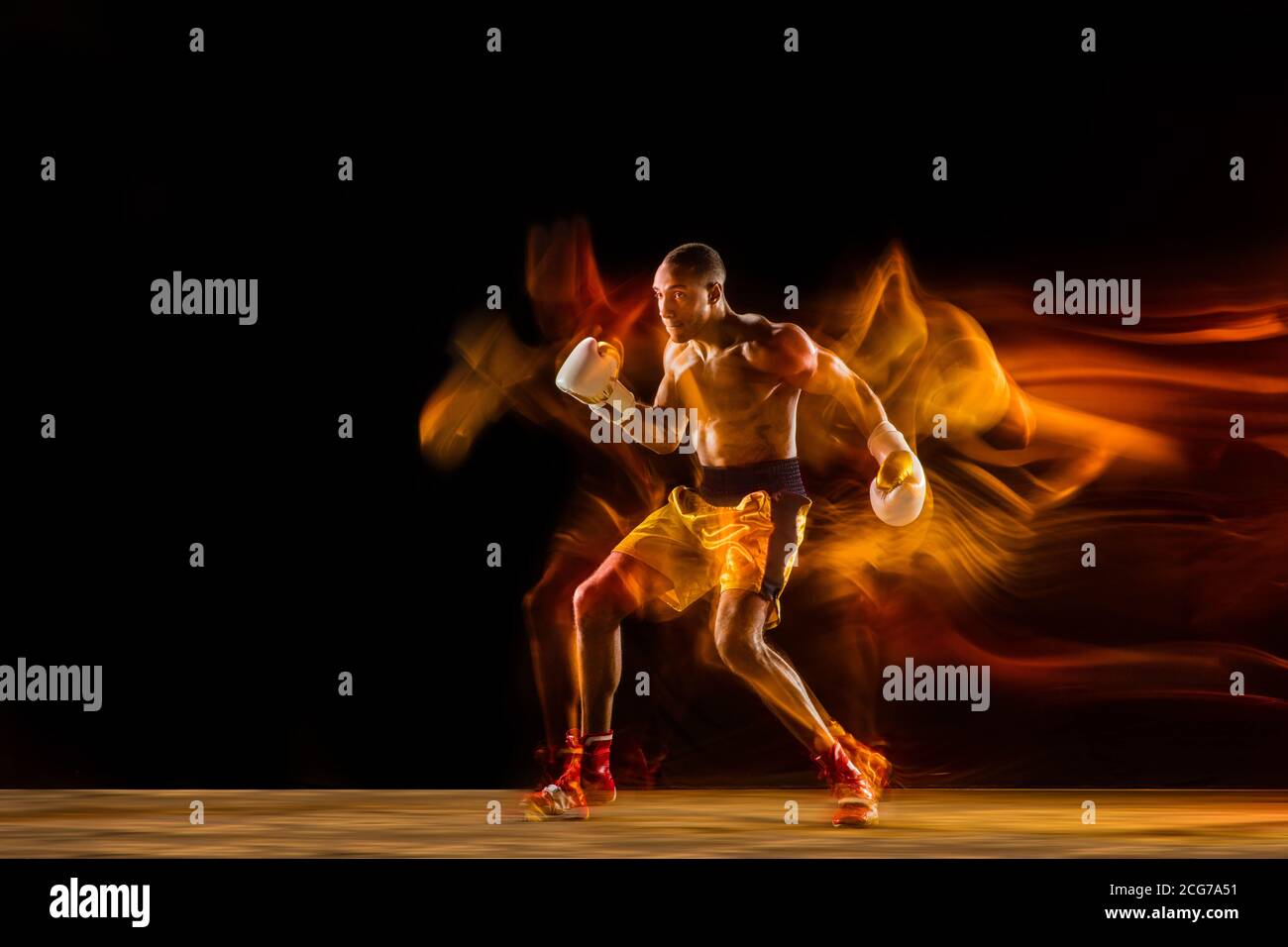 In fire. Professional boxer training isolated on black studio ...