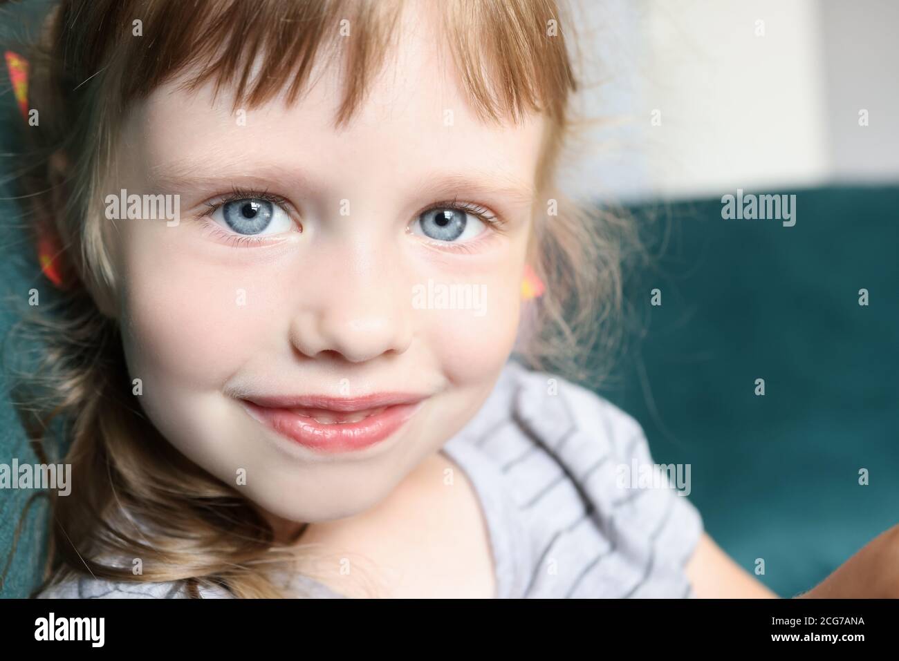 Portrait of little girl with blue eyes and slight smile Stock Photo - Alamy