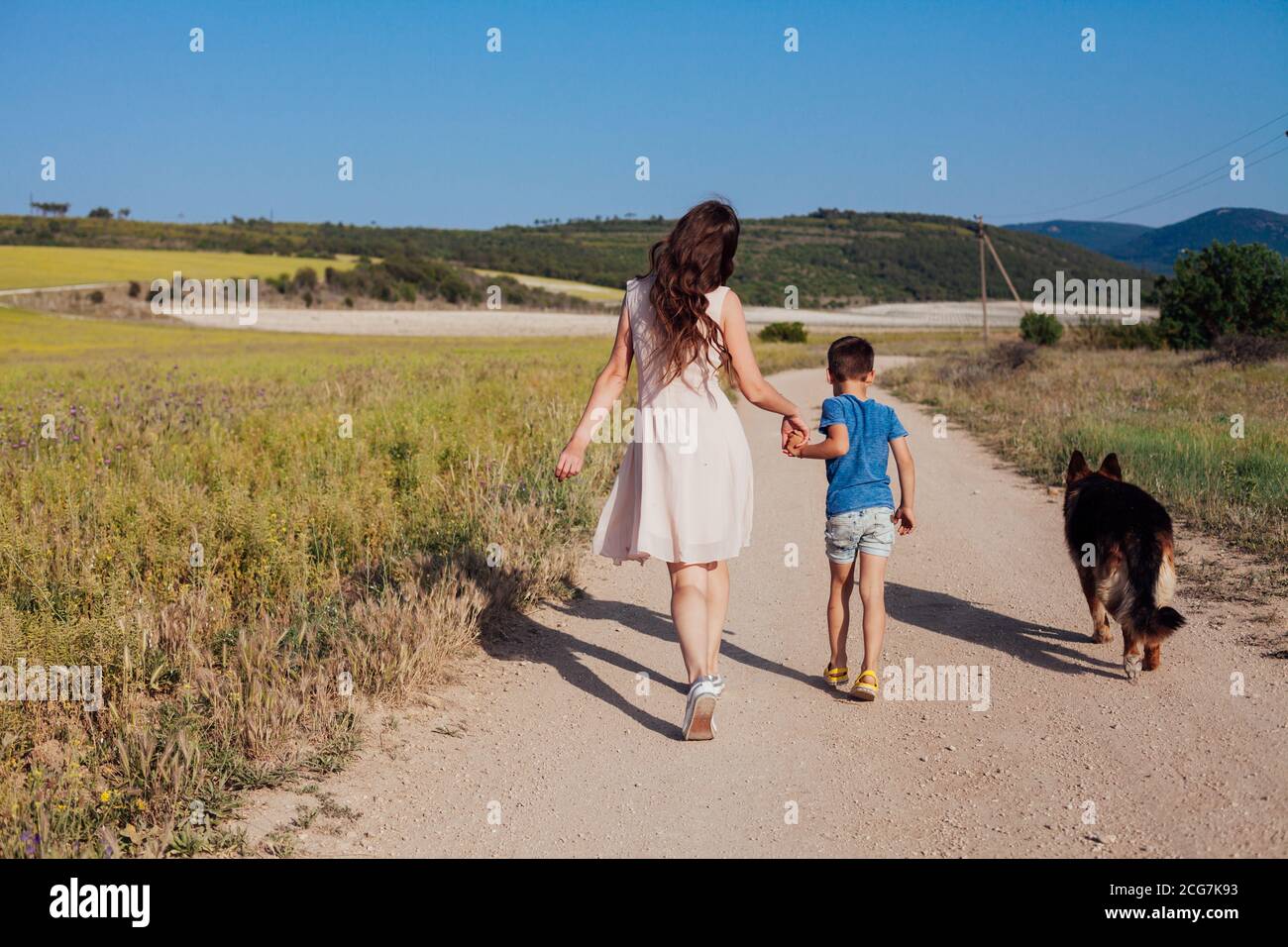 Mother with son and dog walk on rural road Stock Photo - Alamy