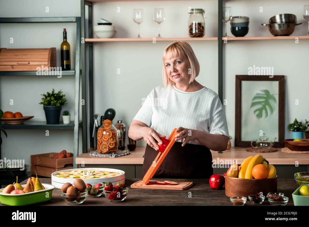 Portrait of content attractive blond-haired lady chef cooking healthy ...