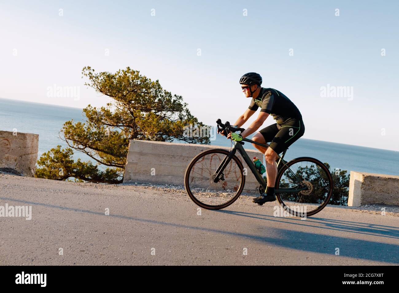 Cycling sport athlete man riding on coastal road Stock Photo - Alamy