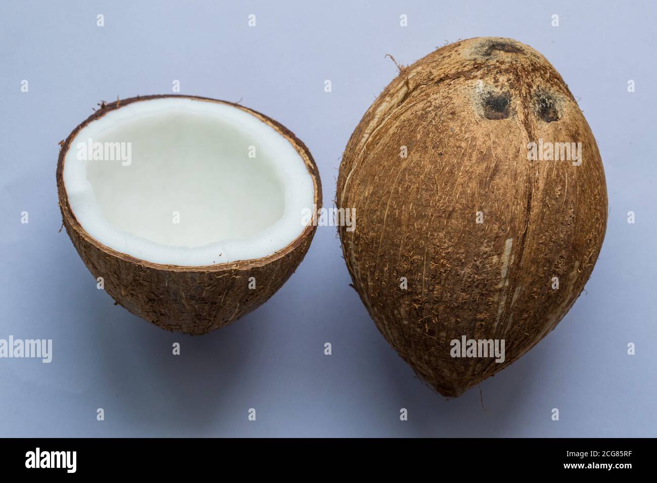 Coconut whole and in half isolated on white background Stock Photo - Alamy