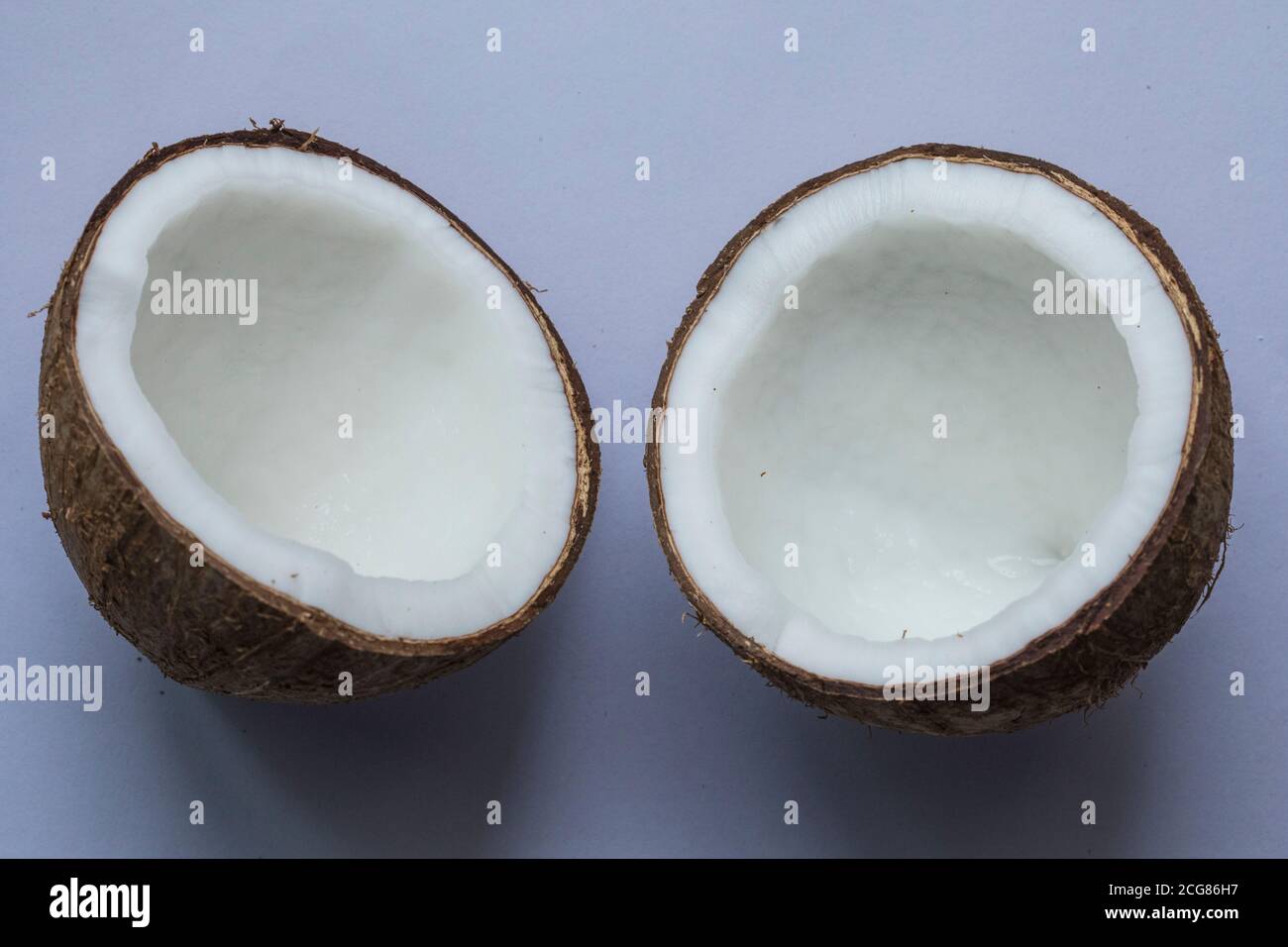Two halves of a coconut on white background Stock Photo - Alamy