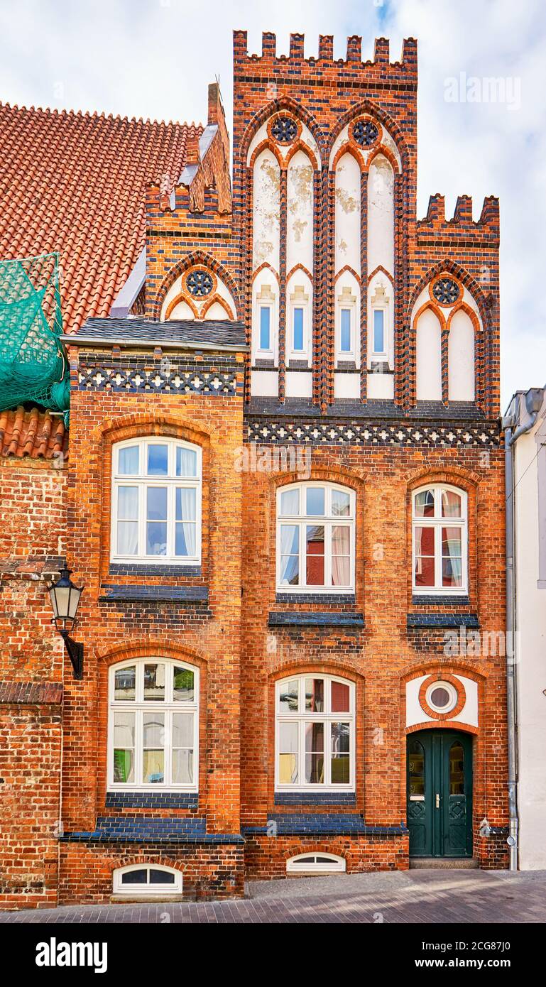 Old gabled house facade with small towers made of red brick in the old town of Wismar Stock ...