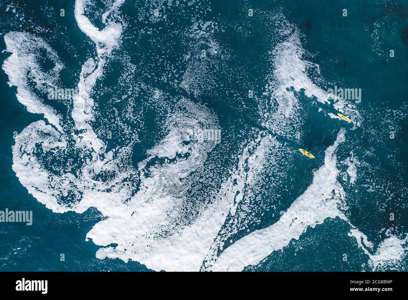 Aerial - Two yellow kayaks cutting through ocean foam Stock Photo - Alamy