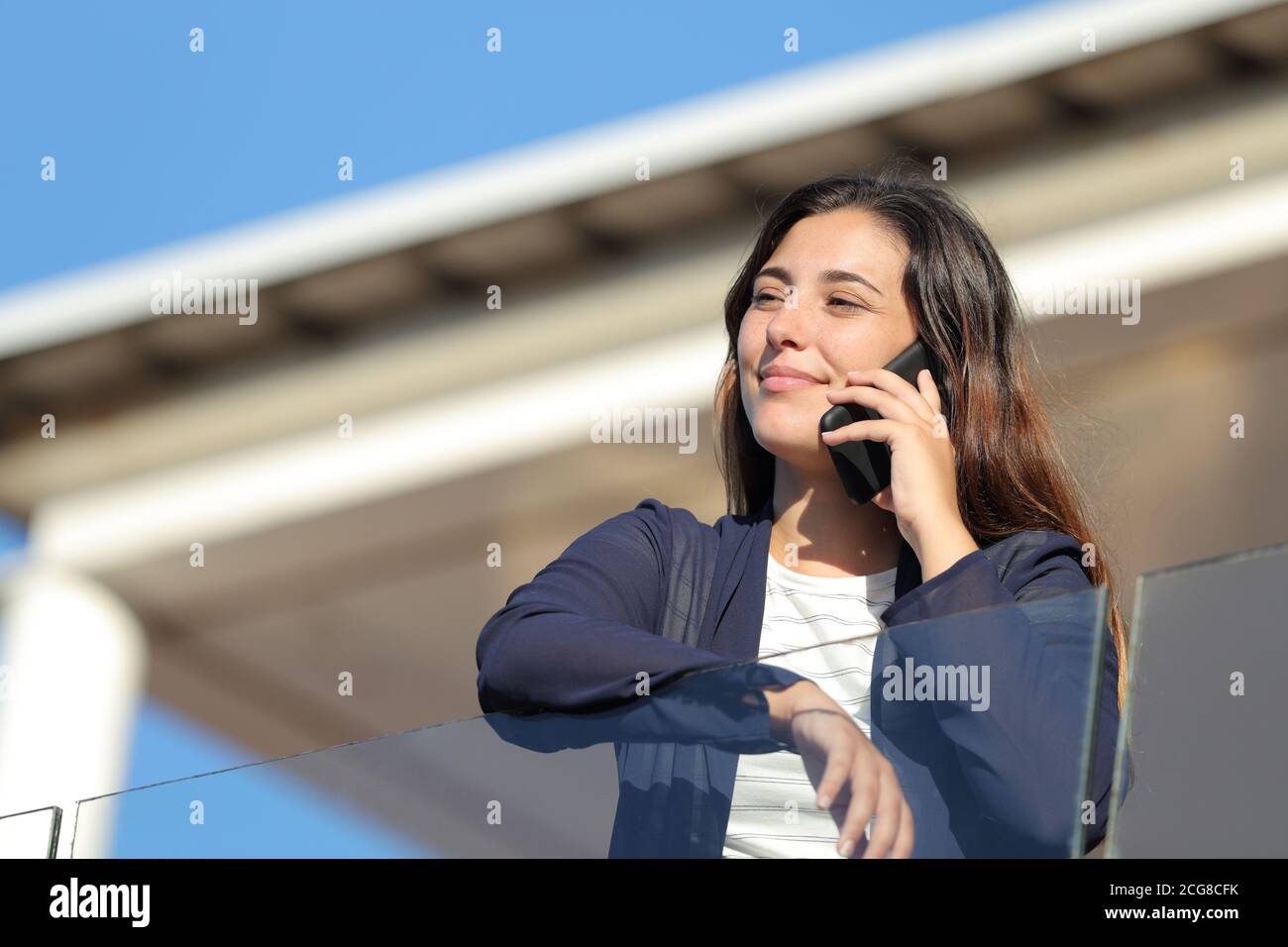Apartment renter calling on phone in a balcony looking away Stock Photo ...