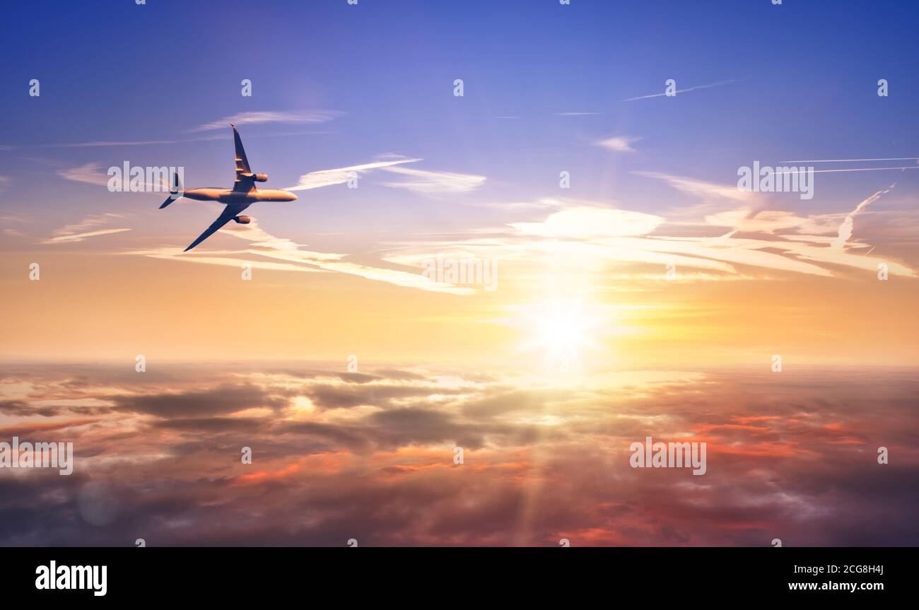 Commercial airplane flying above clouds in dramatic sunset light. High ...