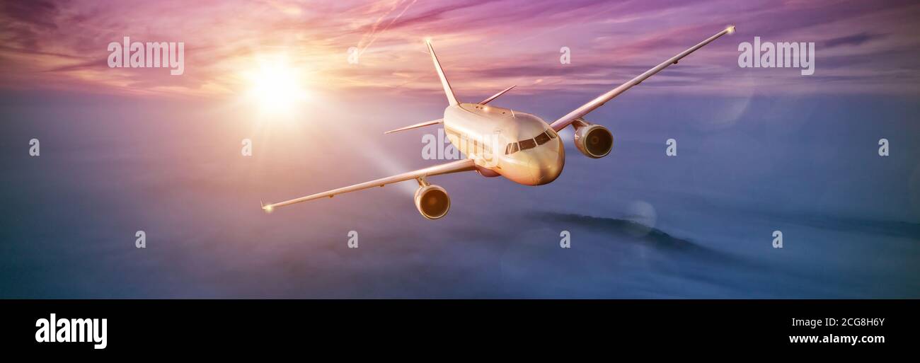 Commercial airplane flying above clouds in dramatic sunset light. High ...