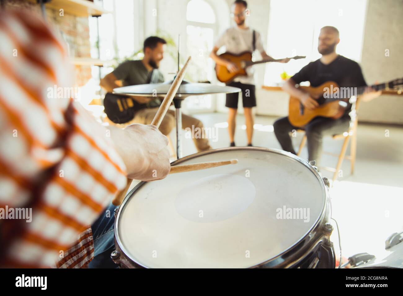 Close up hands playing. Musician band jamming together in art workplace ...