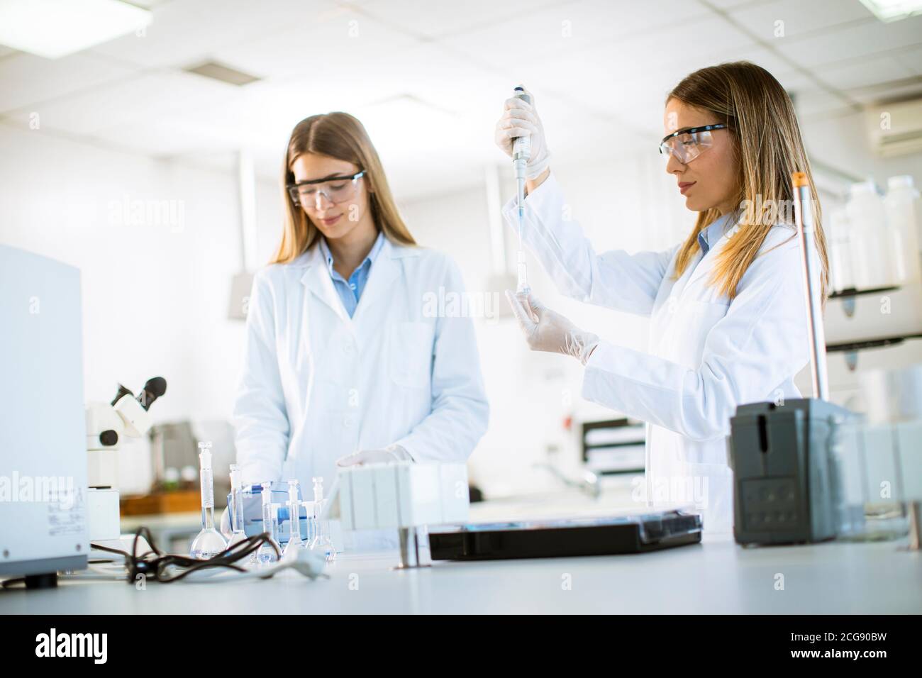 Cute female researchers in white lab coat working in the laboratory ...