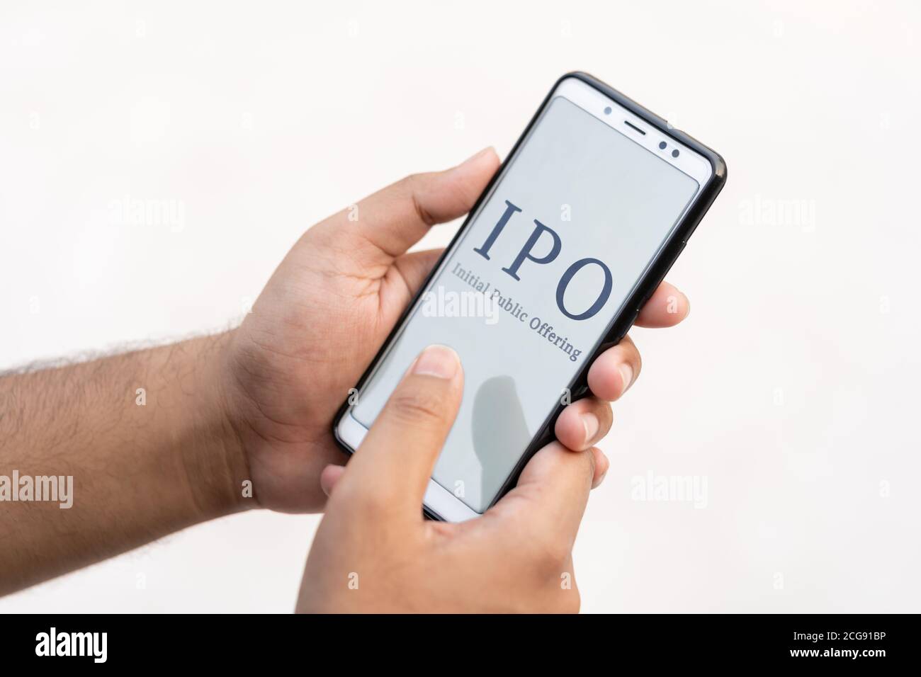 IPO concept. Indian working man hand holding smart phone & showing ...