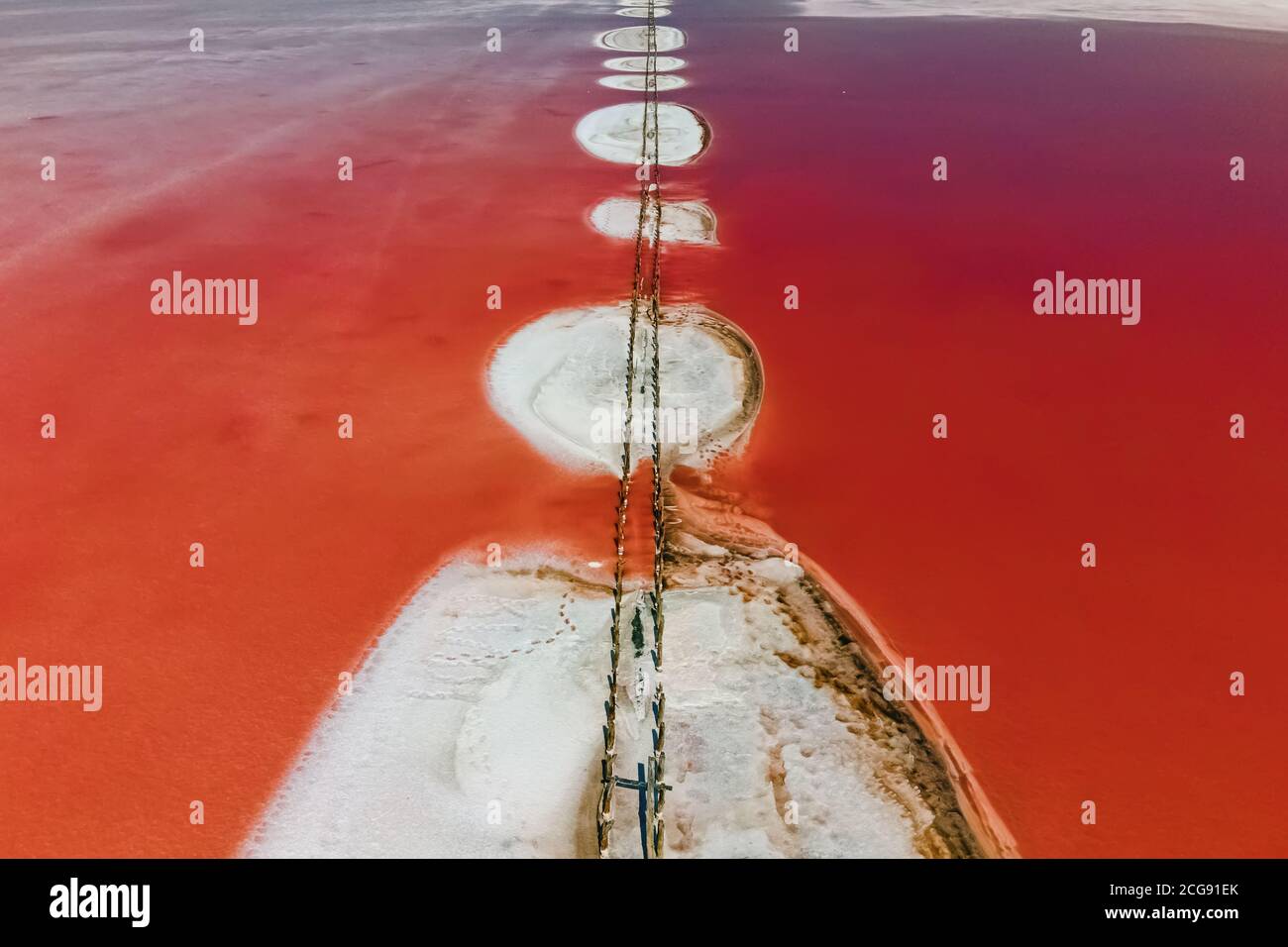 Top aerial view of incredible right pink lake. Salar with wooden beams ...