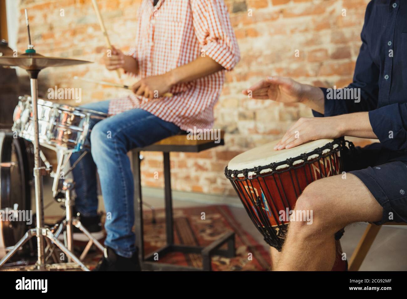 Close up hands playing. Musician band jamming together in art workplace ...