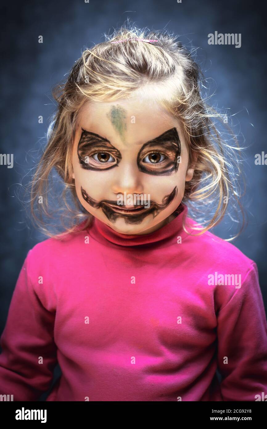 3 year old girl with face made up for halloween event. studio shot ...
