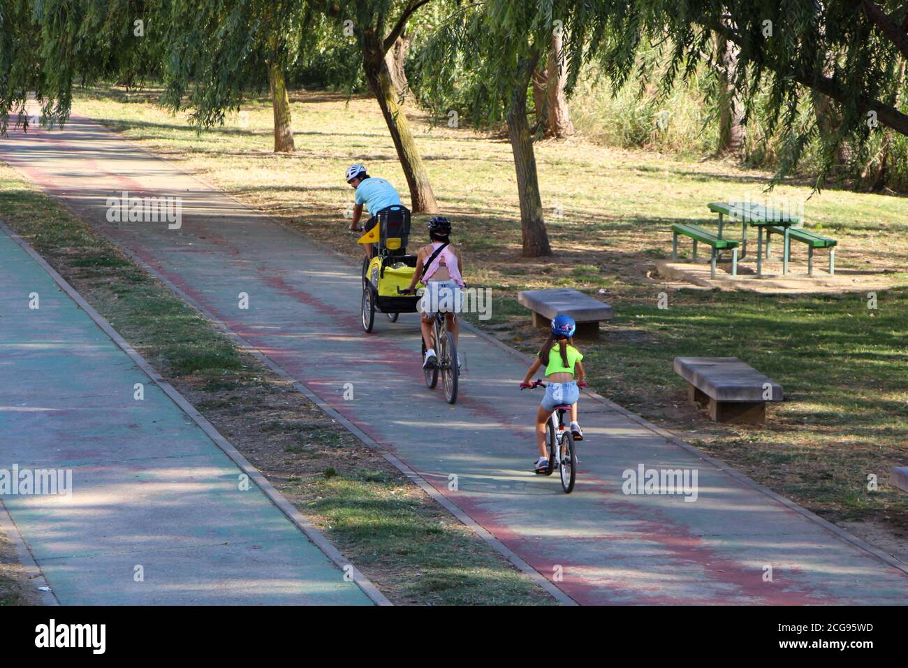 Family riding bicycles along a cycle path next to the River Carrion in ...