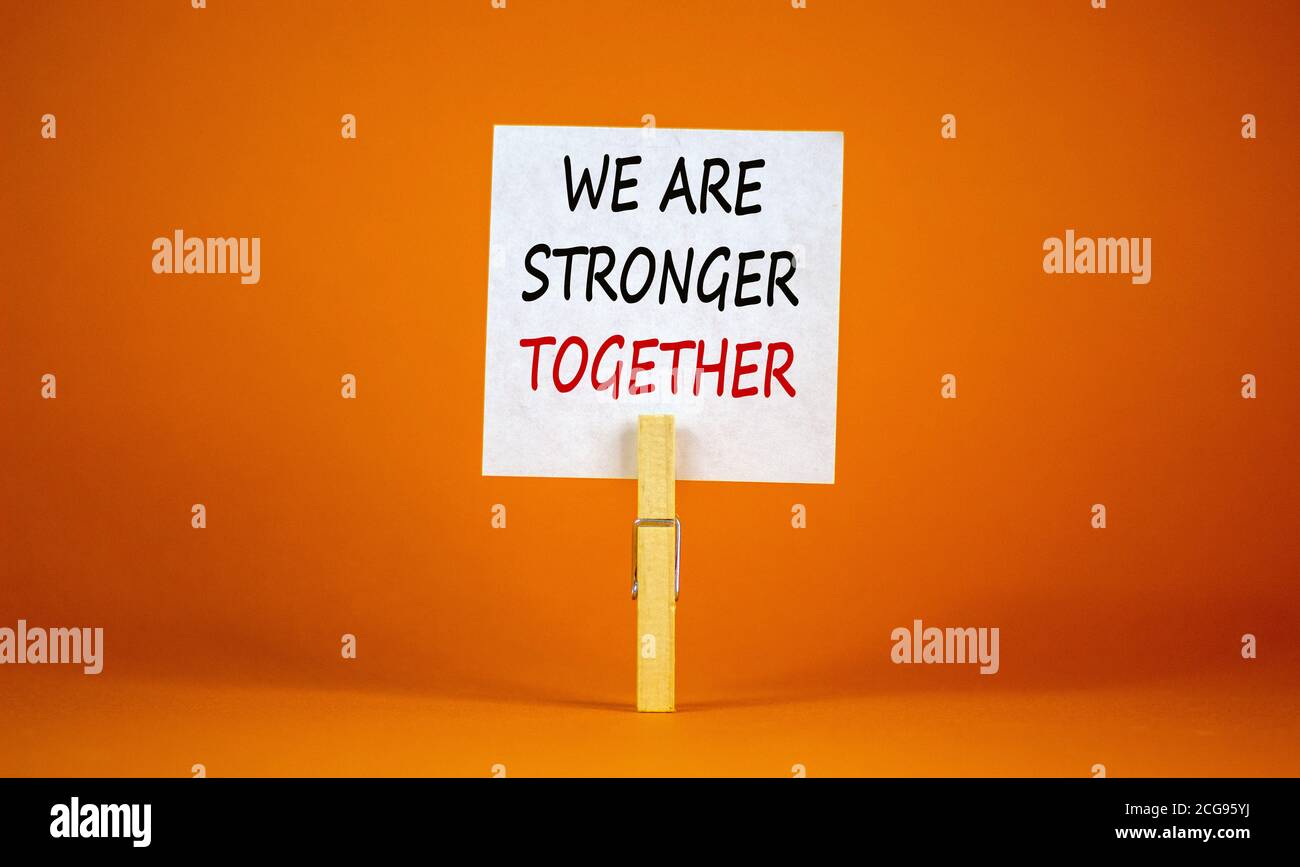 Wooden clothespin with white sheet of paper. Text 'we are stronger ...
