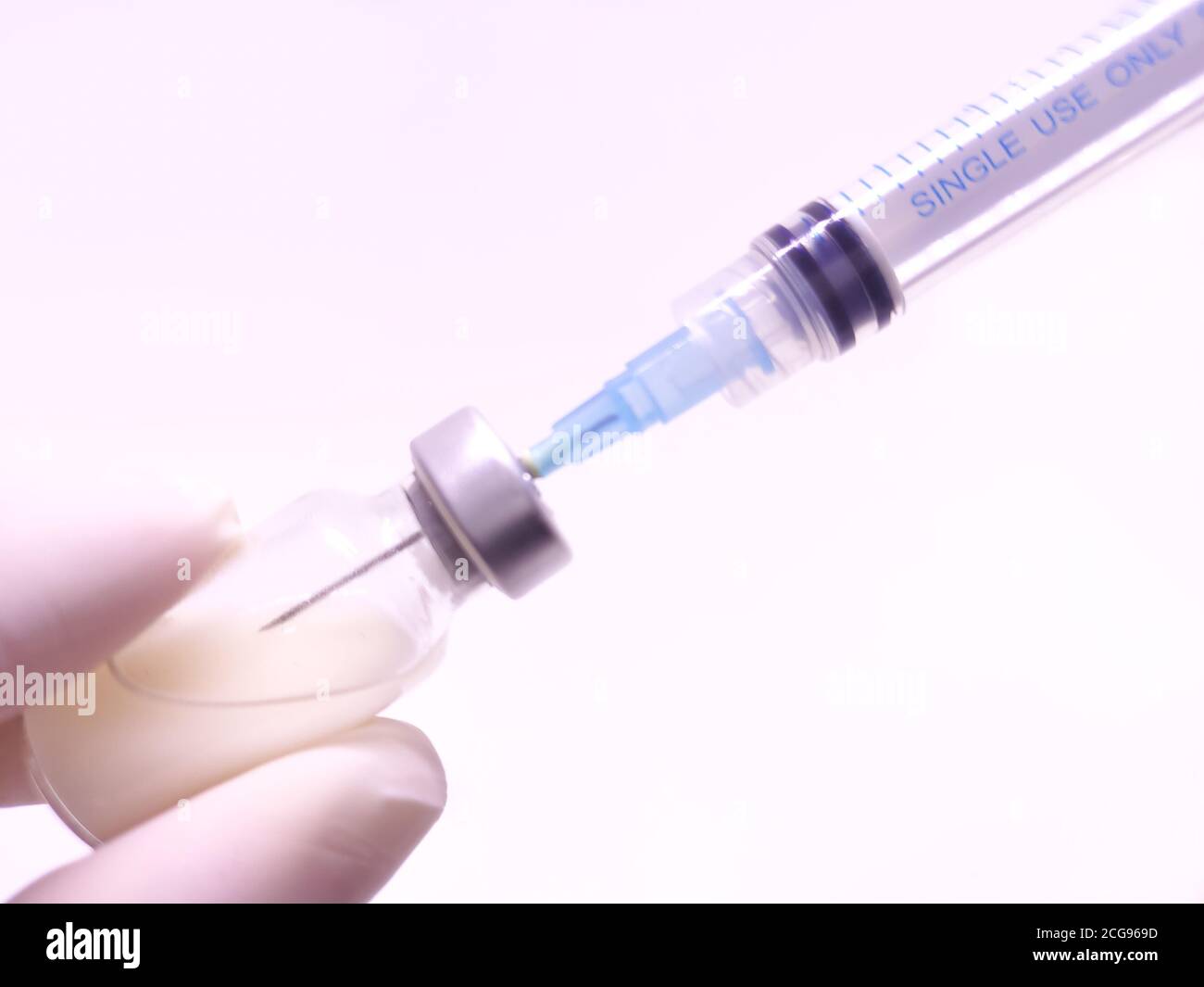 Hand holding syringe and vaccine vial prepare for injection with ...