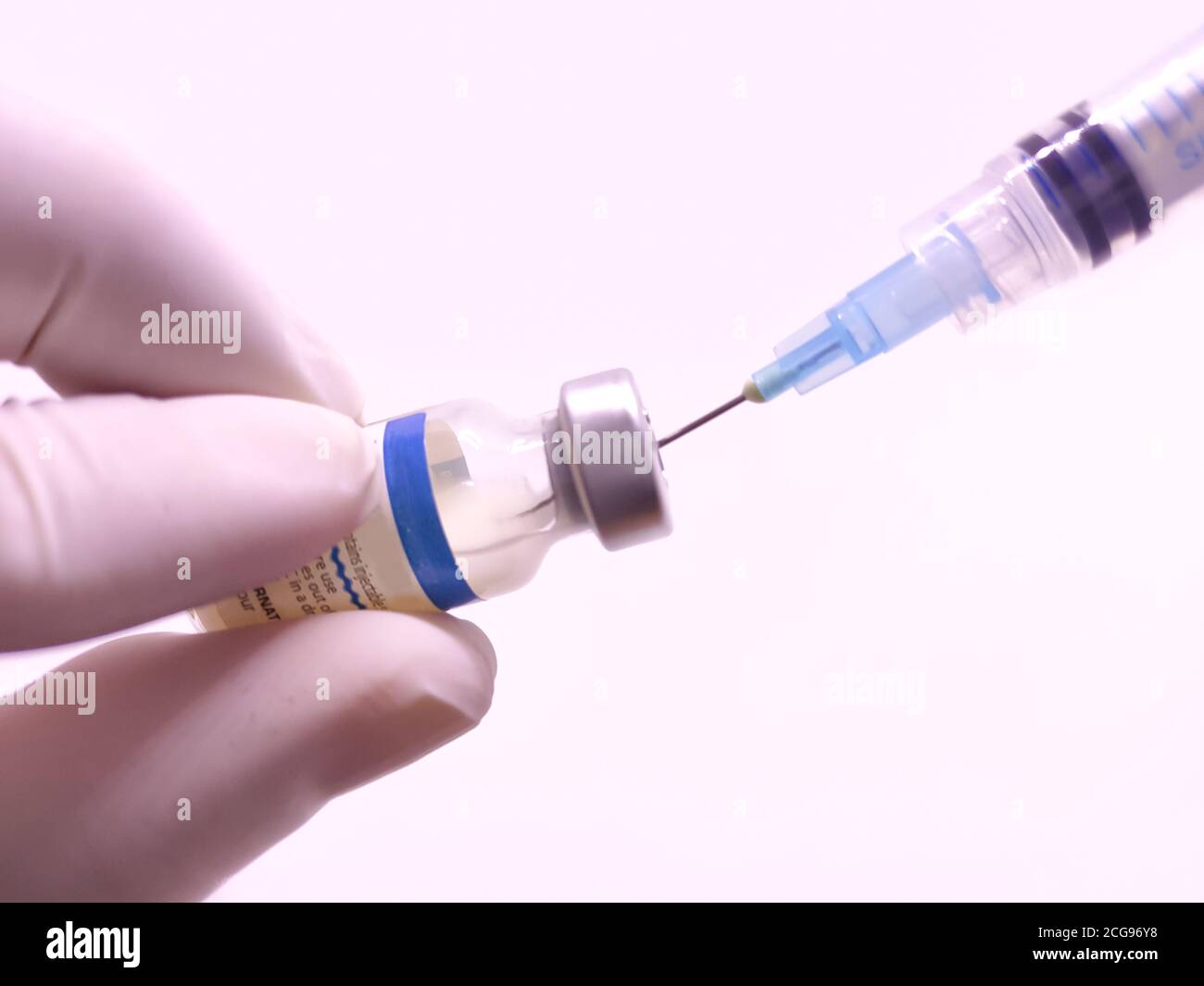 Hand holding syringe and vaccine vial prepare for injection with ...
