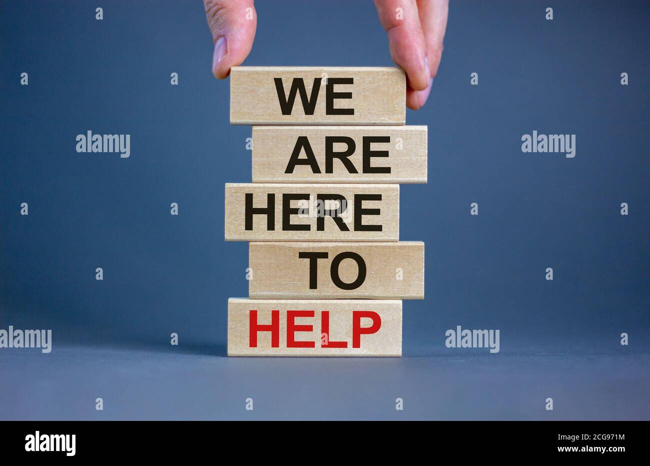 Wooden blocks with text 'we are here to help'. Male hand. Beautiful ...